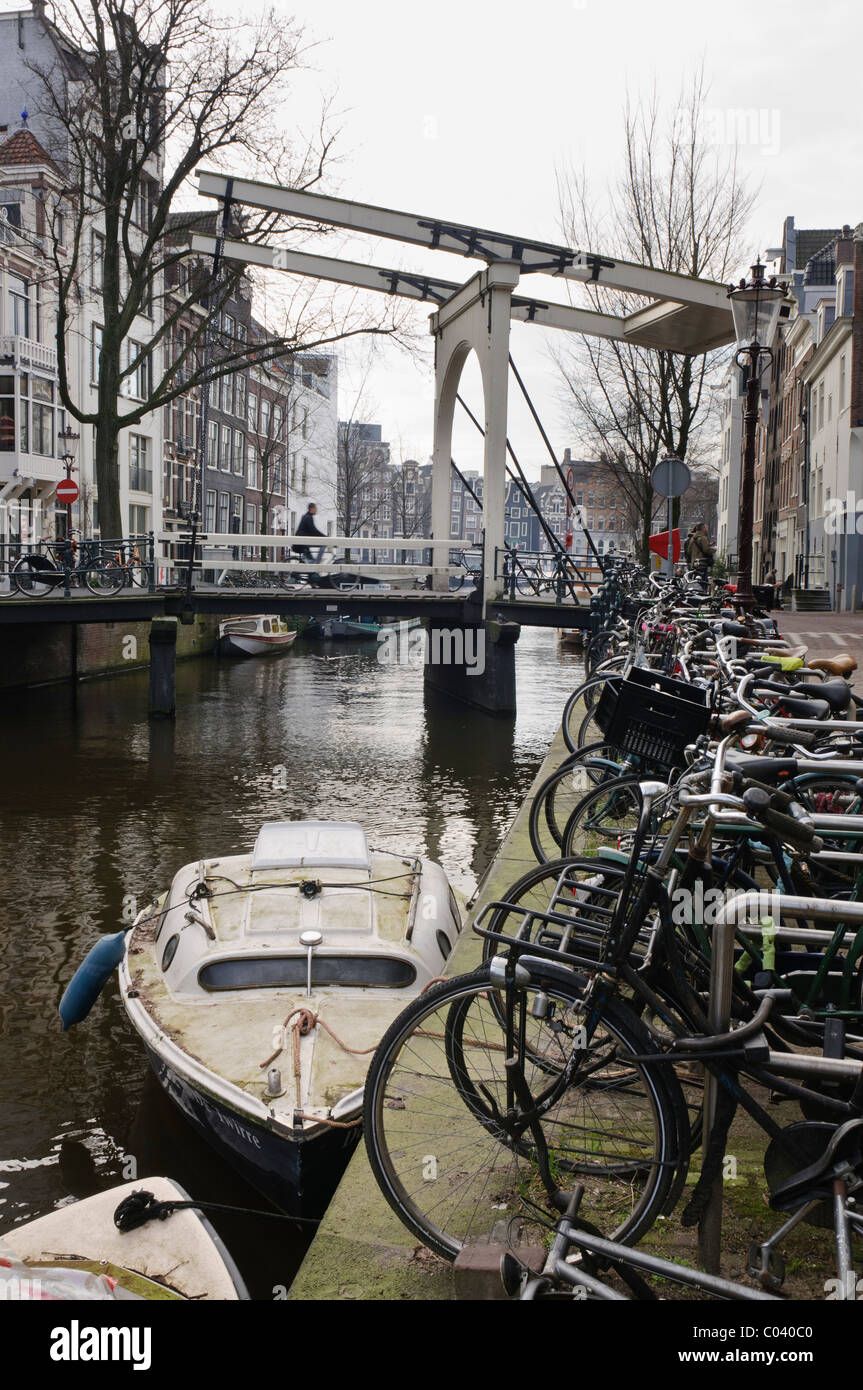 Bridge over a canal in Amsterdam with boats and bicycles Stock Photo ...