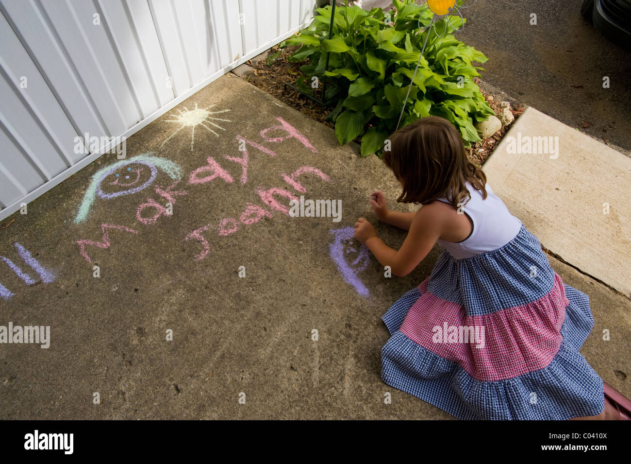 Young girl drawing name with chalk on sidewalk Stock Photo - Alamy