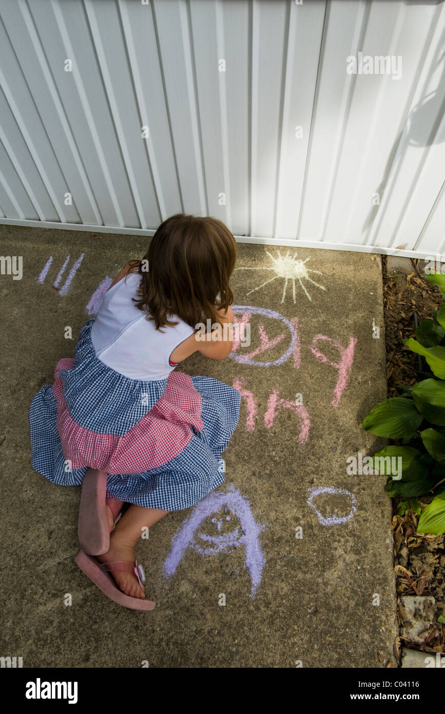 Young girl drawing name with chalk on sidewalk Stock Photo - Alamy
