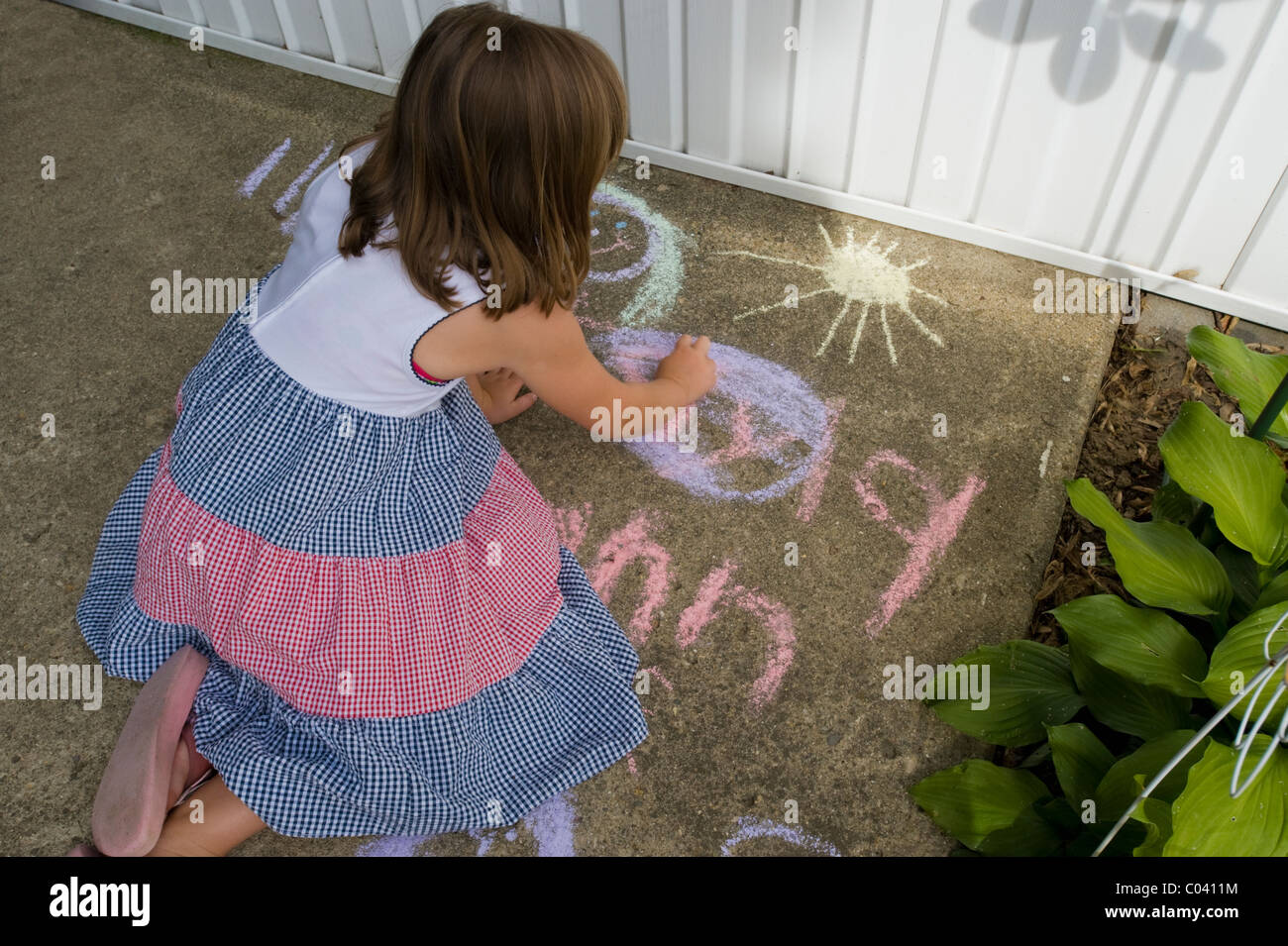 Young girl drawing name with chalk on sidewalk Stock Photo - Alamy