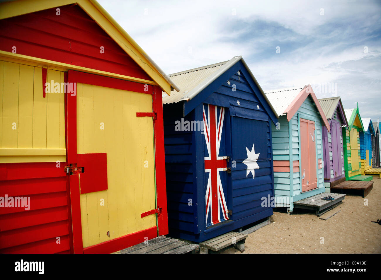 Brightly coloured wooden bathing huts line the beach at Brighton ...