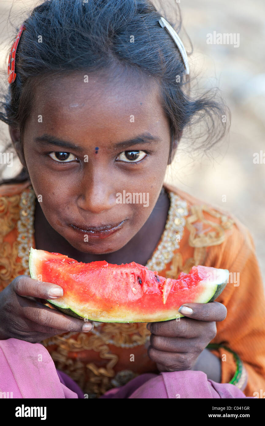 Happy young poor lower caste Indian street girl eating a slice of ...
