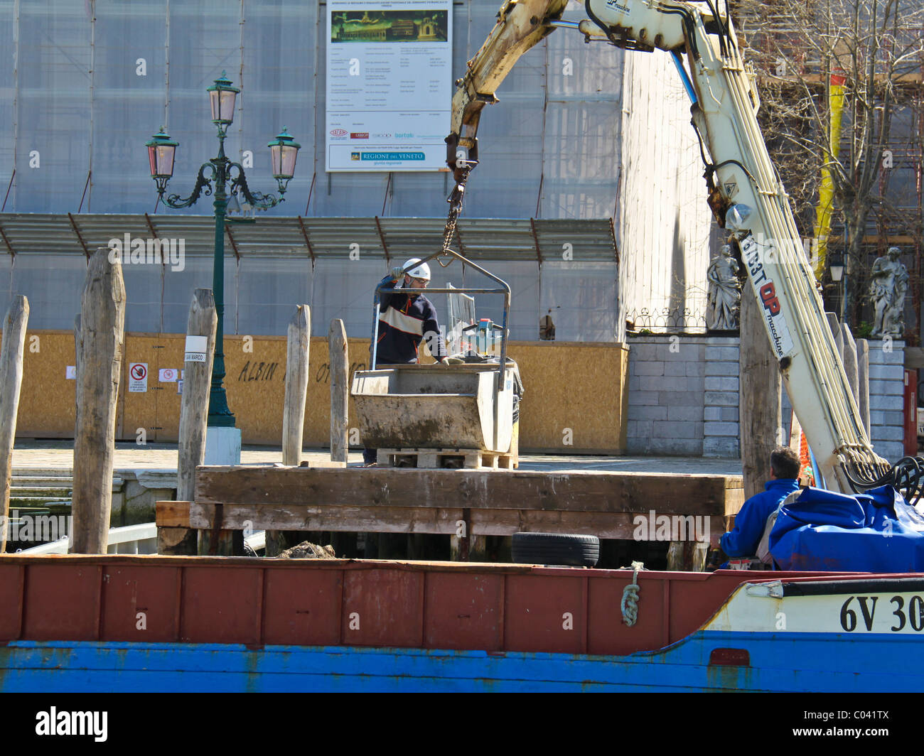Workshop boat unloading building supplies from canal in Venice Stock ...