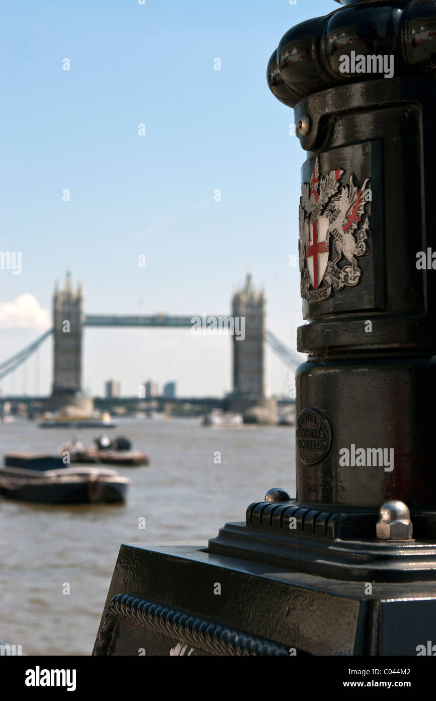 Closeup of the City of London Emblem on a lamppost with Tower Bridge in ...