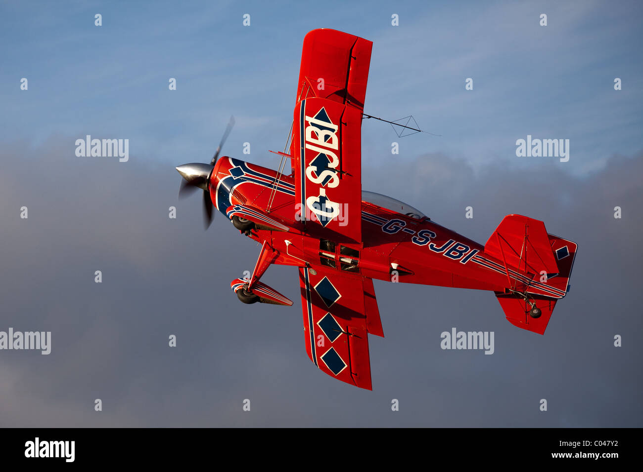 An aerobatic red Pitts S2-C biplane flying at Compton Abbas airfield in ...