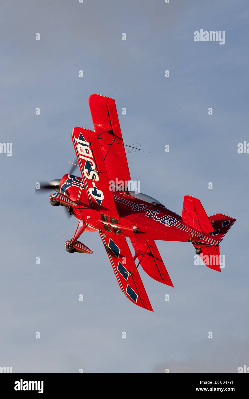 An aerobatic red Pitts S2-C biplane flying at Compton Abbas airfield in ...