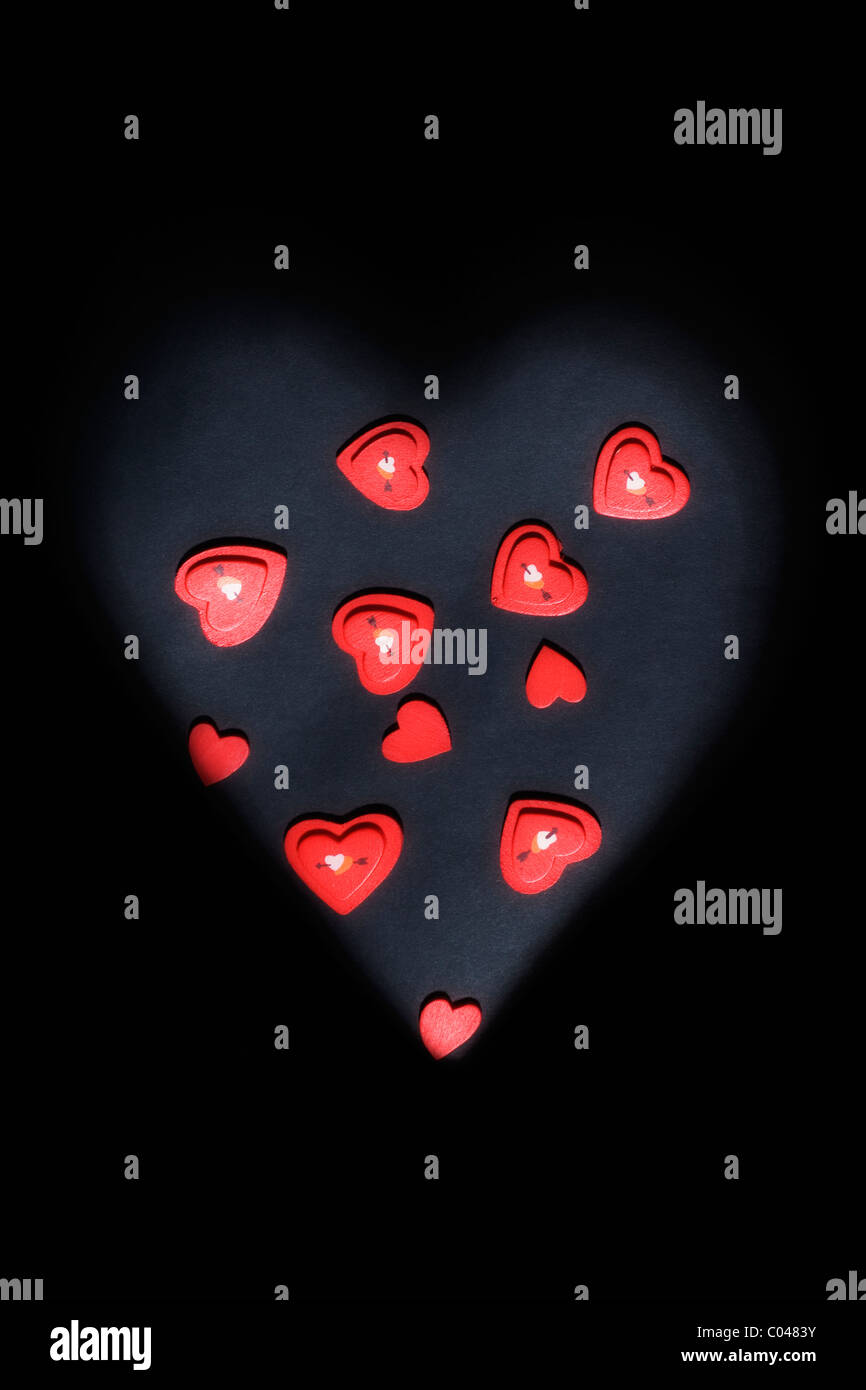 red hearts in light against black background Stock Photo - Alamy