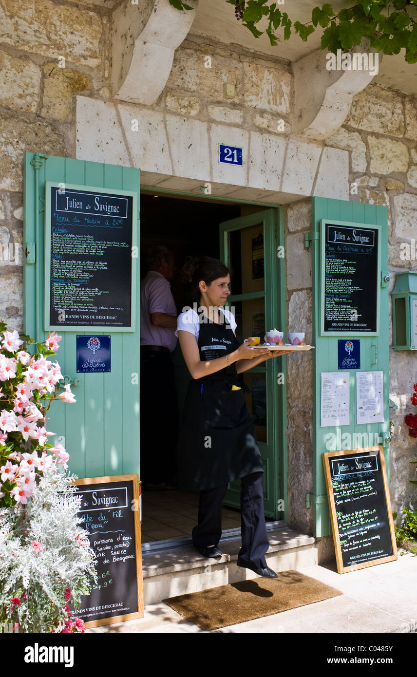 Waitress serving at French outdoor cafe in tourist town Brantome in the ...