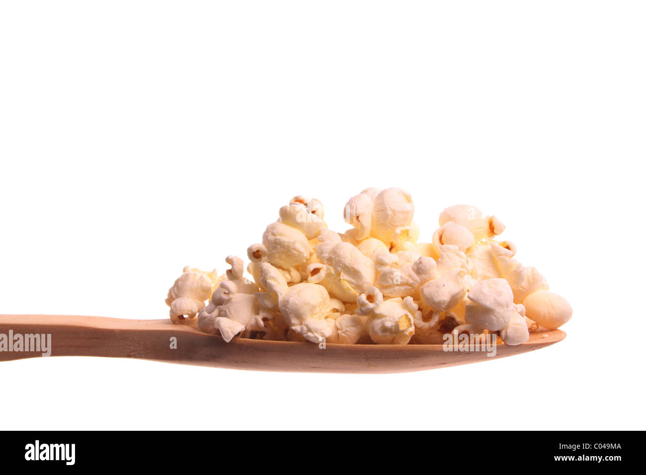 Popcorn simply offered on a wooden spoon isolated on a white background ...