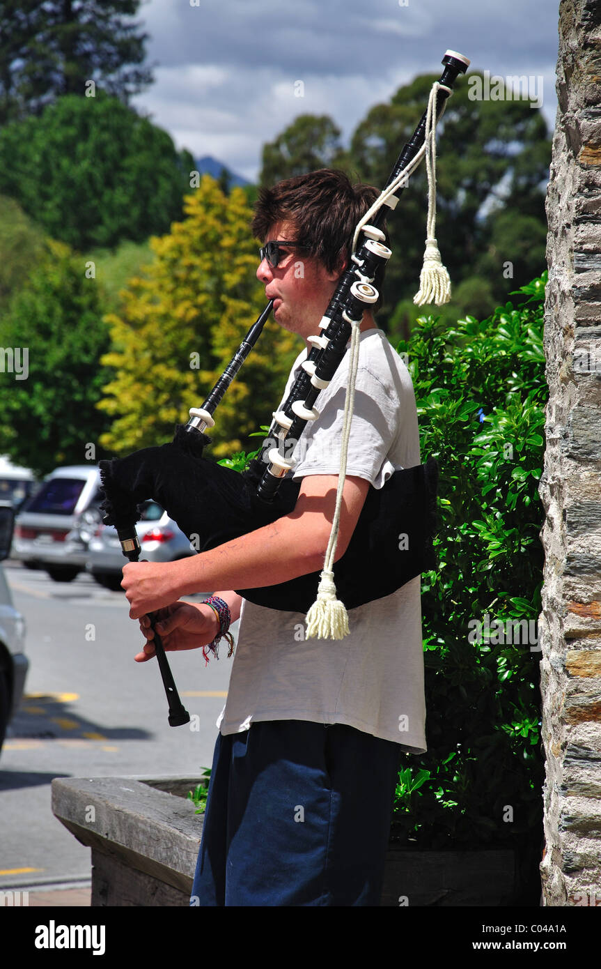 Young busker playing bagpipes in town centre, Queenstown, Otago Region ...