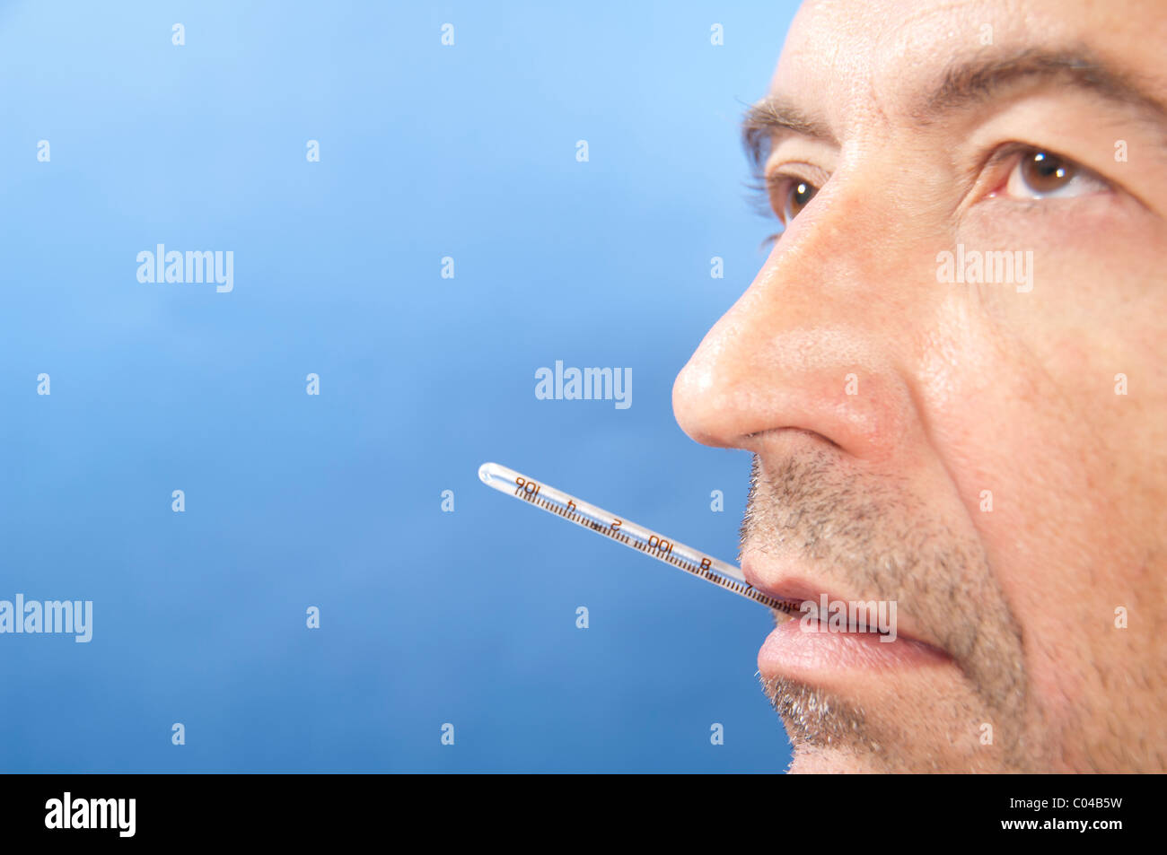 Man with fever thermometer in his mouth Stock Photo - Alamy