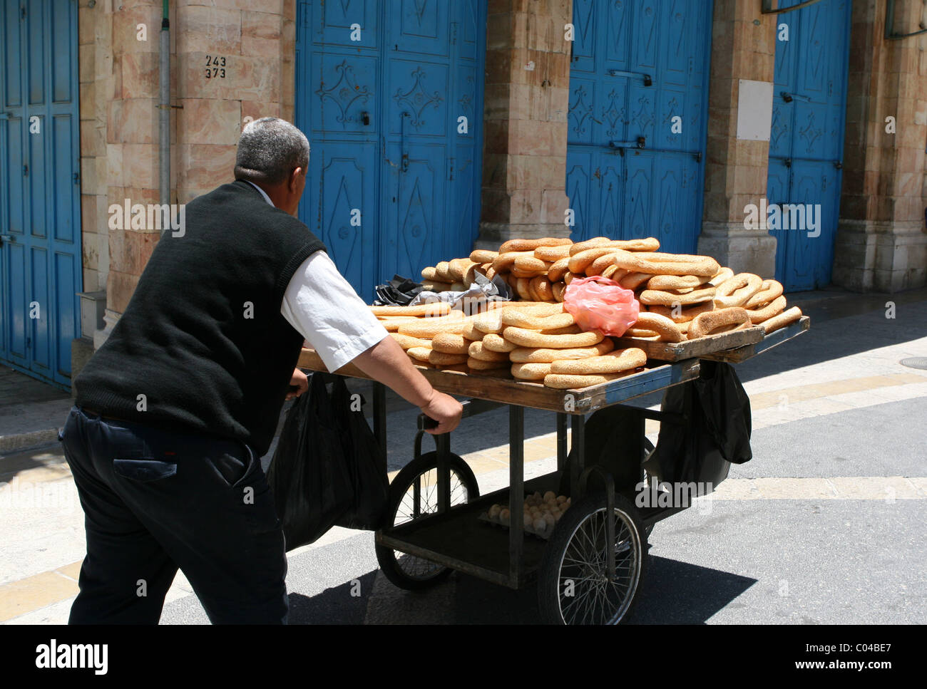A street vendor pushs his bread cart through the streets of Jerusalem ...