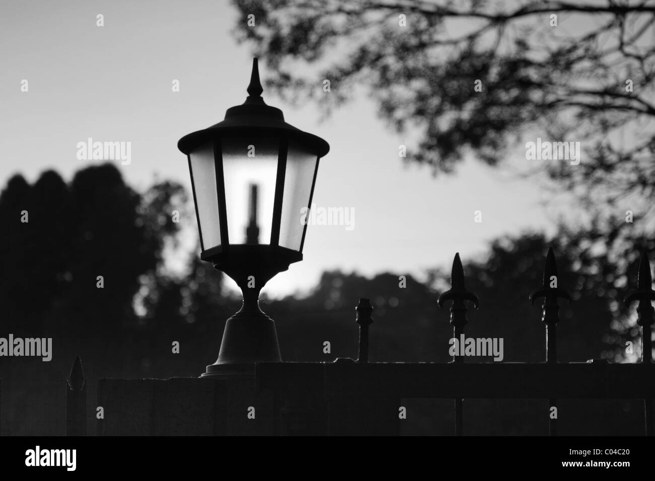 Classic styled outdoor gate lantern highlighted by sunlight at dawn ...