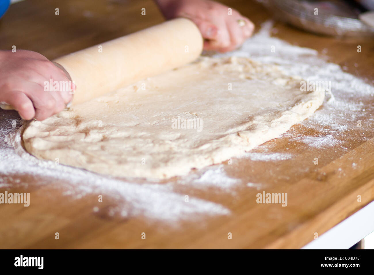 Woman flattening dough, preparing it to become cinnamon buns Stock ...