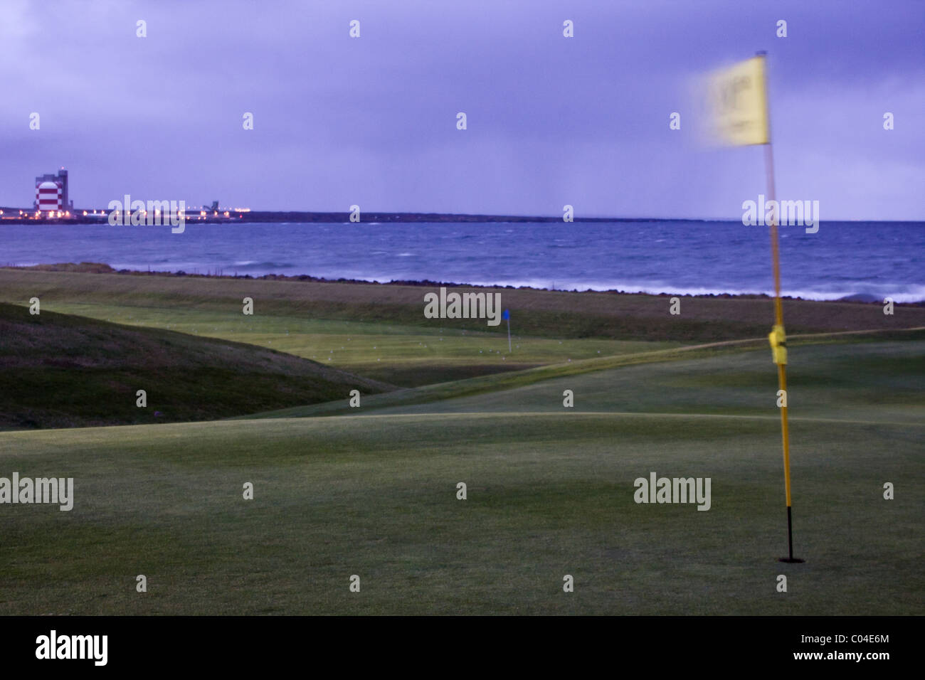 A golf flag struggles in the wind at a golf course in Hafnarfjordur ...