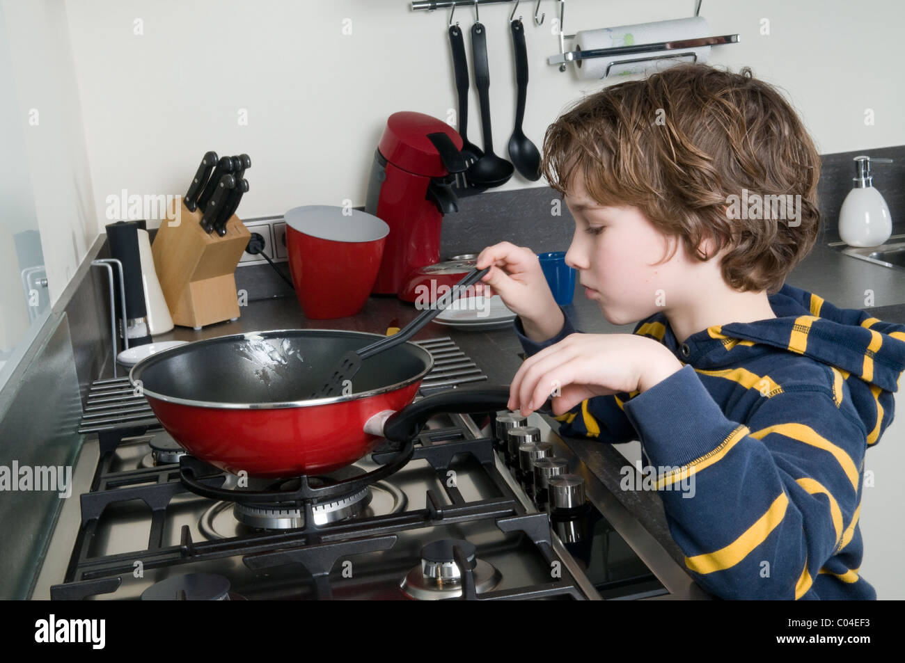 Young boy learning to cook in a modern kitchen Stock Photo - Alamy