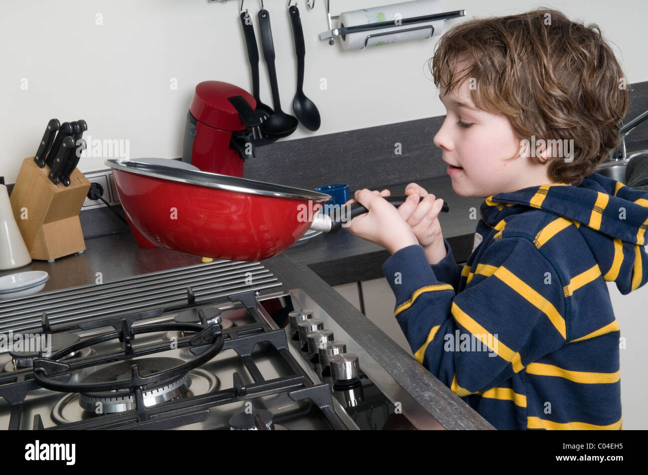 Young boy learning to cook in a modern kitchen Stock Photo - Alamy