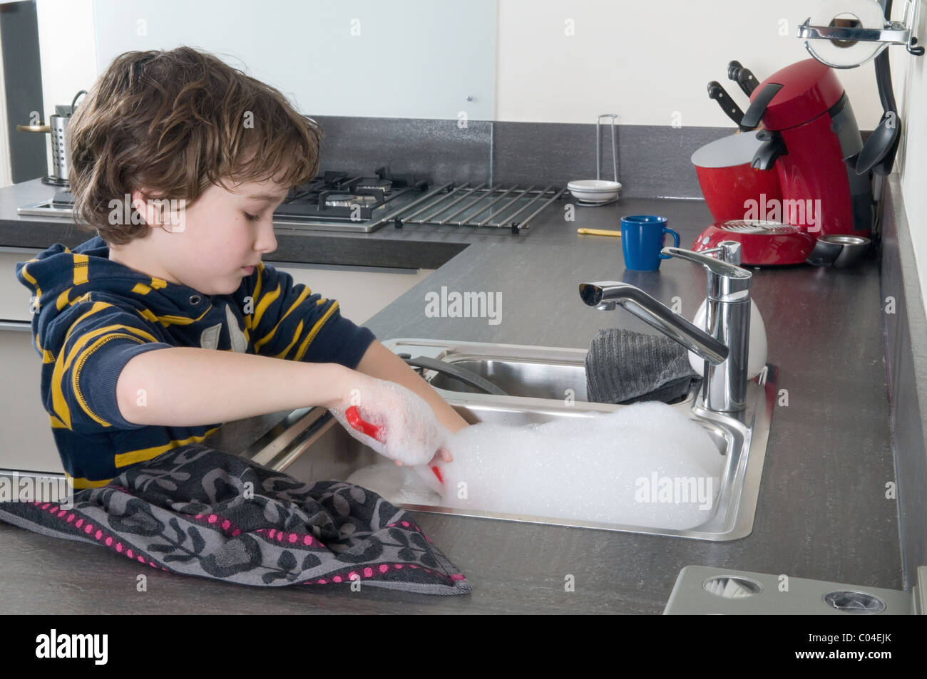 Boy doing the dishes in a modern kitchen Stock Photo - Alamy