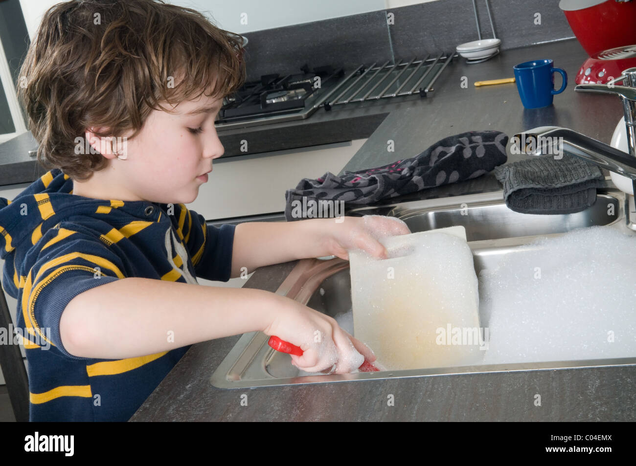Boy doing the dishes in a modern kitchen Stock Photo - Alamy