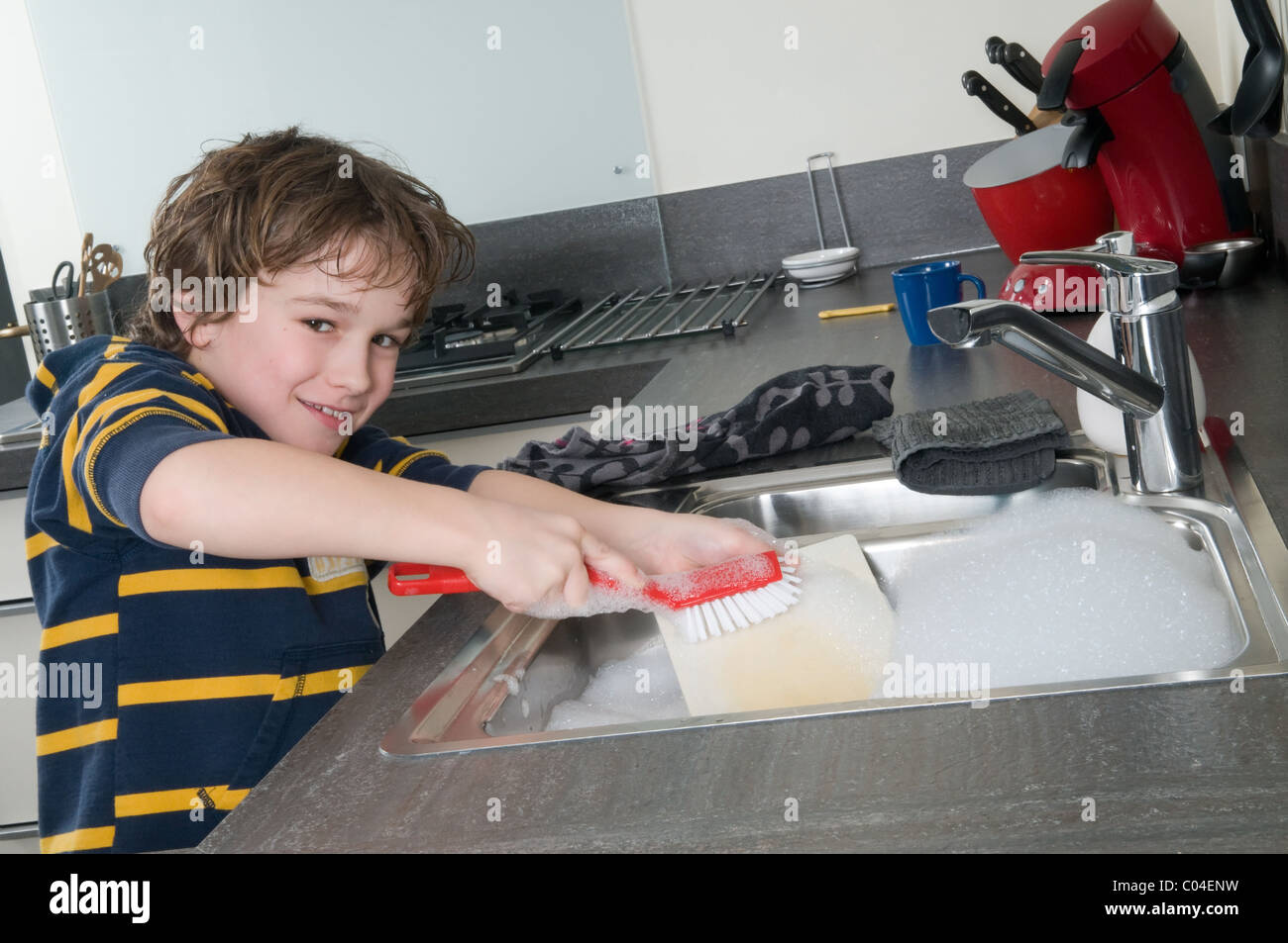Boy doing the dishes in a modern kitchen Stock Photo - Alamy