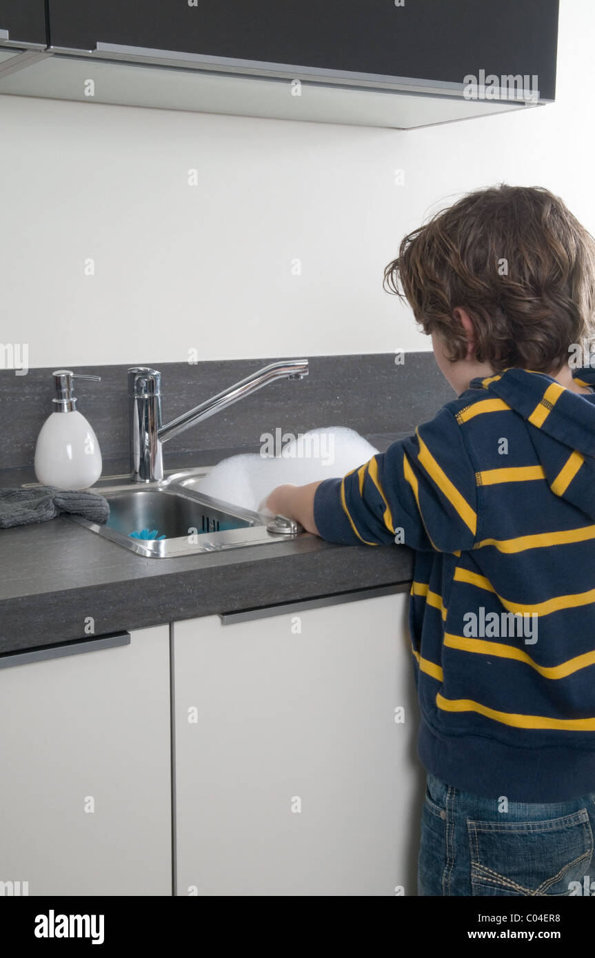 Boy doing the dishes in a modern kitchen Stock Photo - Alamy