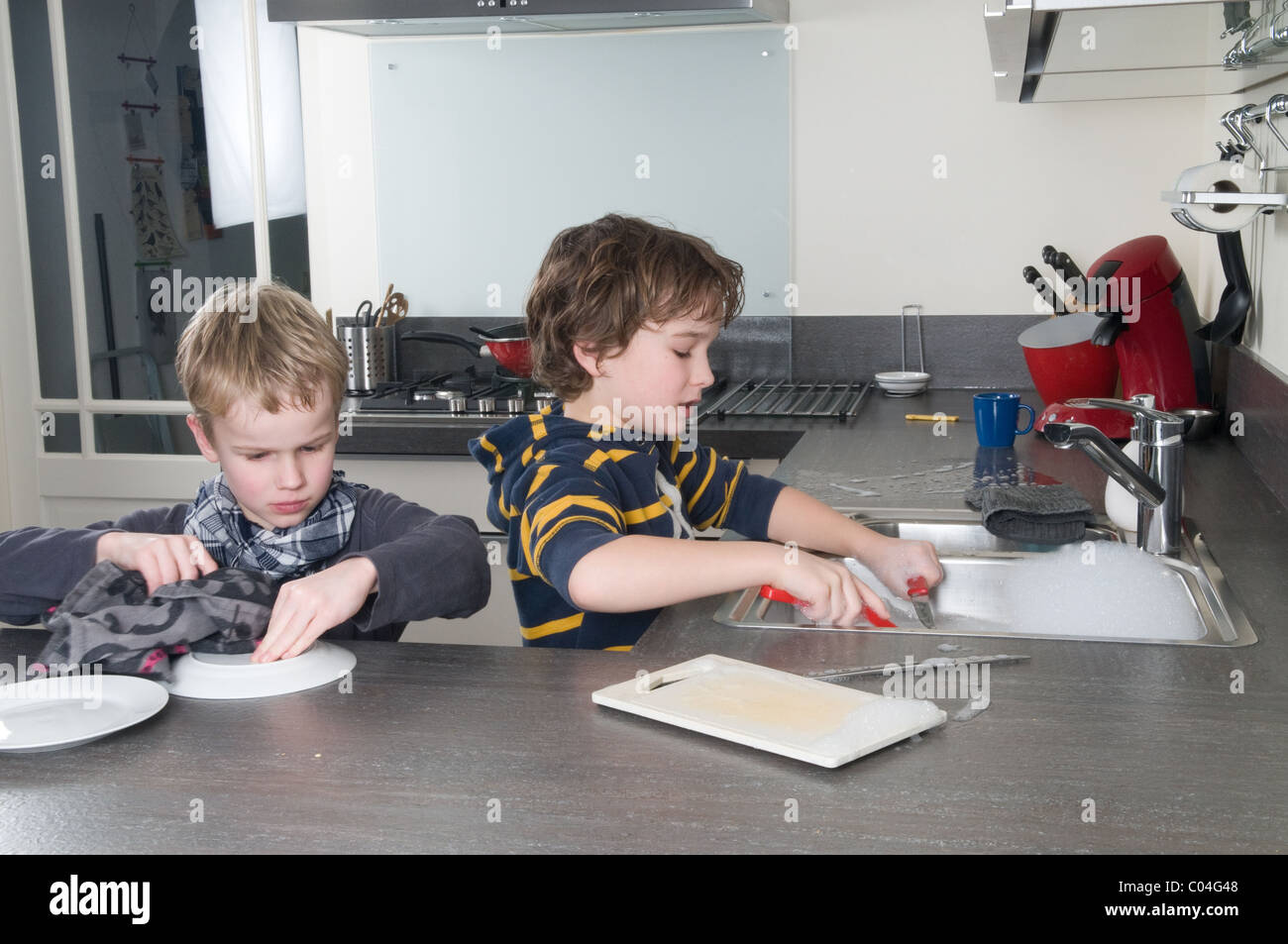 Two boys doing the dishes in a modern kitchen Stock Photo - Alamy