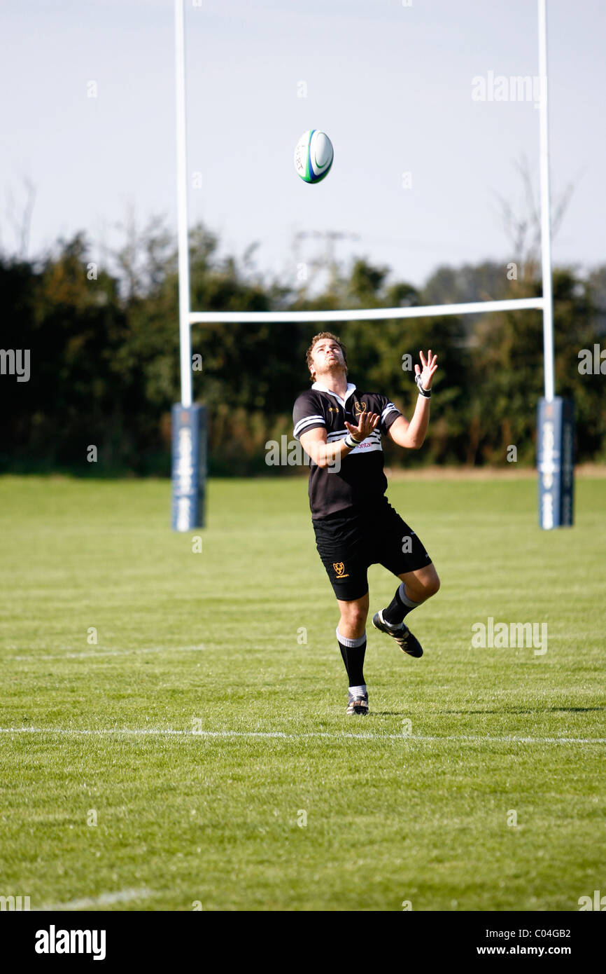 Male rugby player about to catch a ruby ball during a game in the UK ...