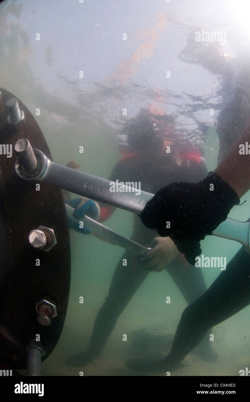 Workers laying a brine discharge pipe from a desalination plant on the ...