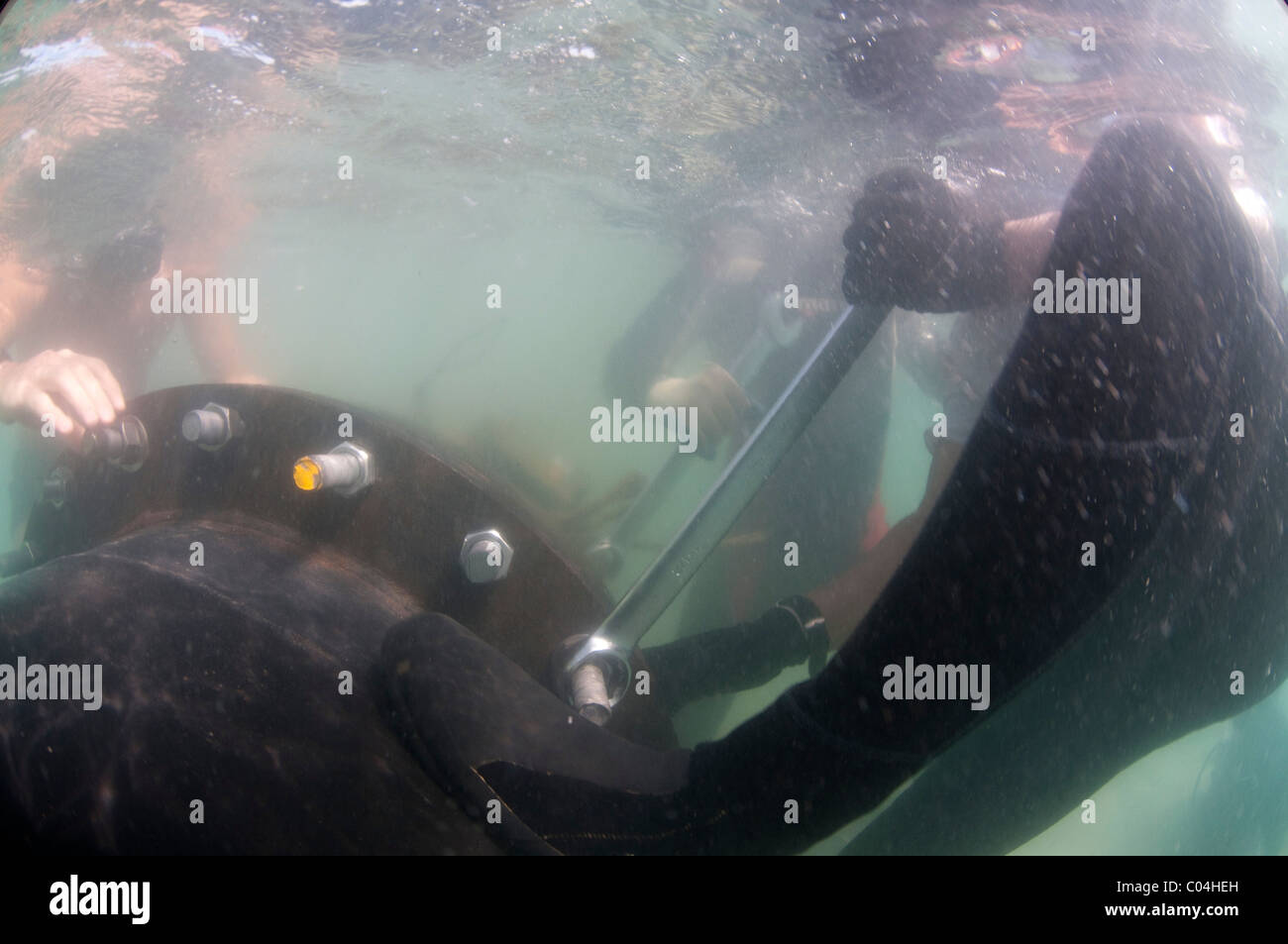 Workers laying a brine discharge pipe from a desalination plant on the ...