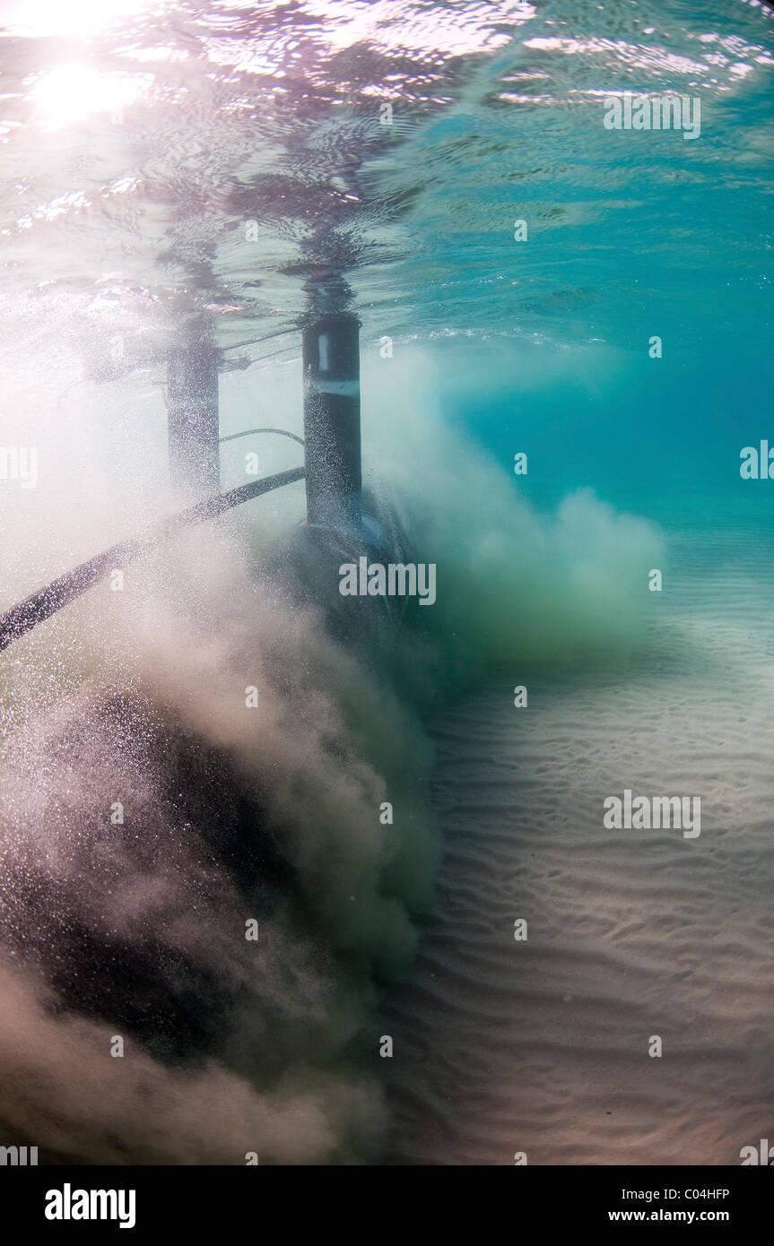 Workers laying a brine discharge pipe from a desalination plant on the ...