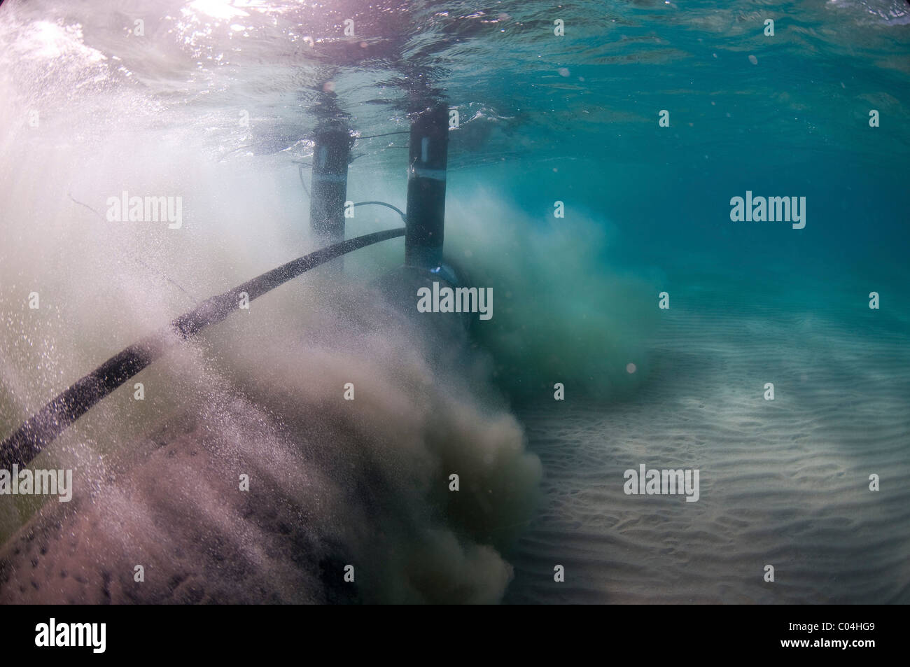 Workers laying a brine discharge pipe from a desalination plant on ...