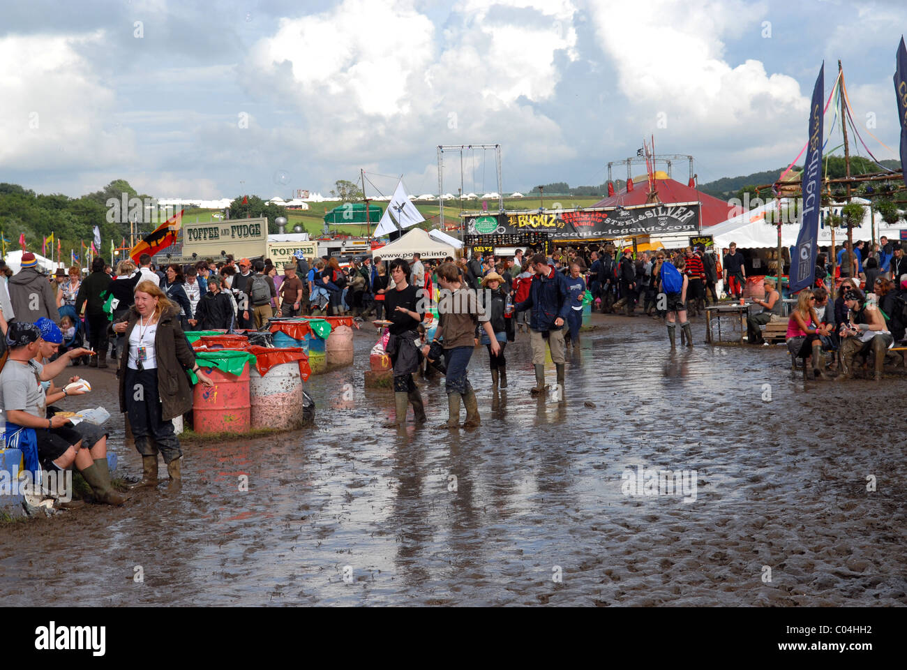 Festival goers walking through the mud at Glastonbury Festival ...
