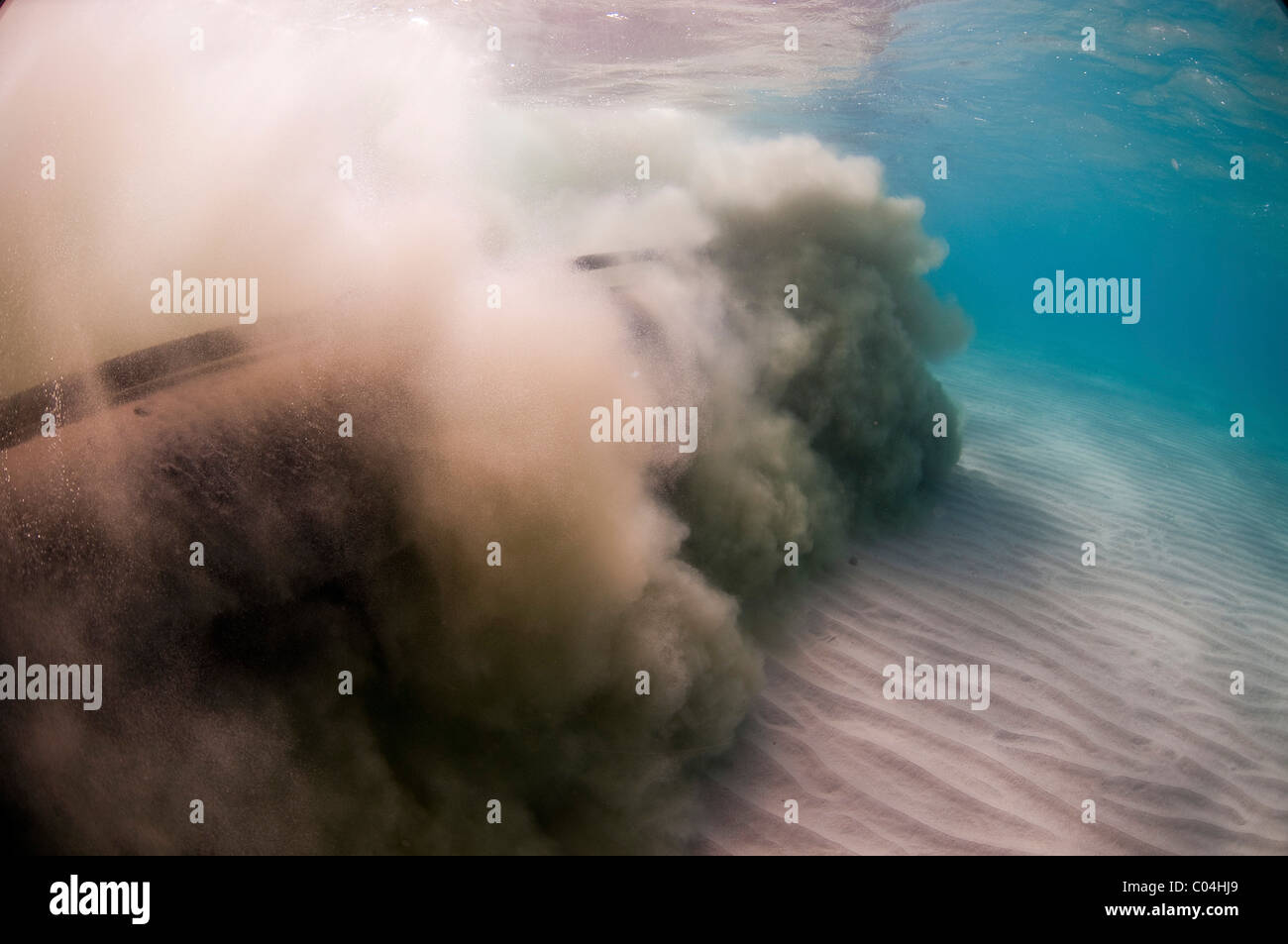 Workers laying a brine discharge pipe from a desalination plant on the ...