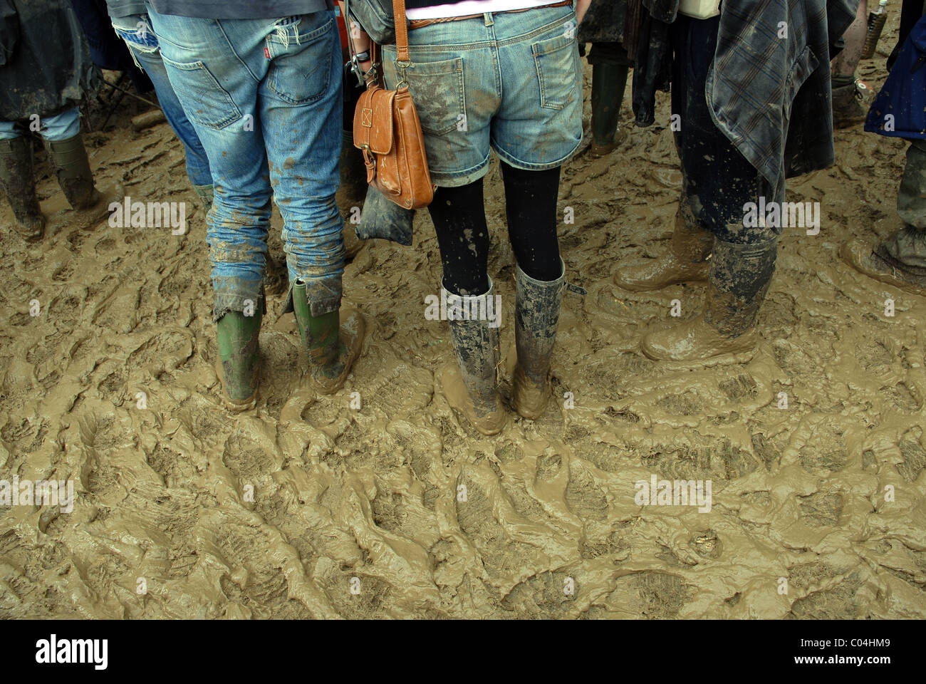 Young people standing in the mud at Glastonbury Festival, Somerset, UK ...