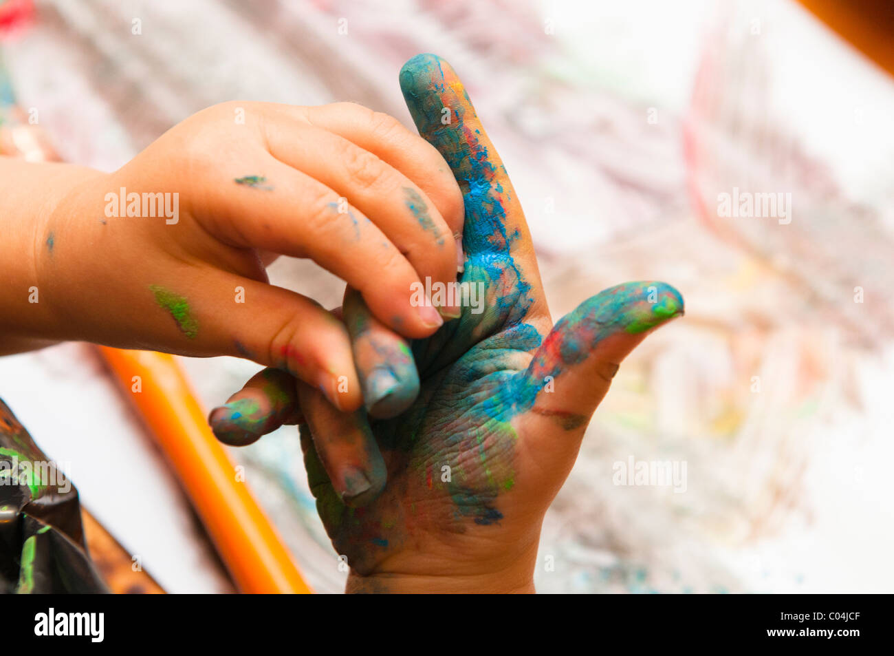 Hands of child doing finger painting Stock Photo - Alamy