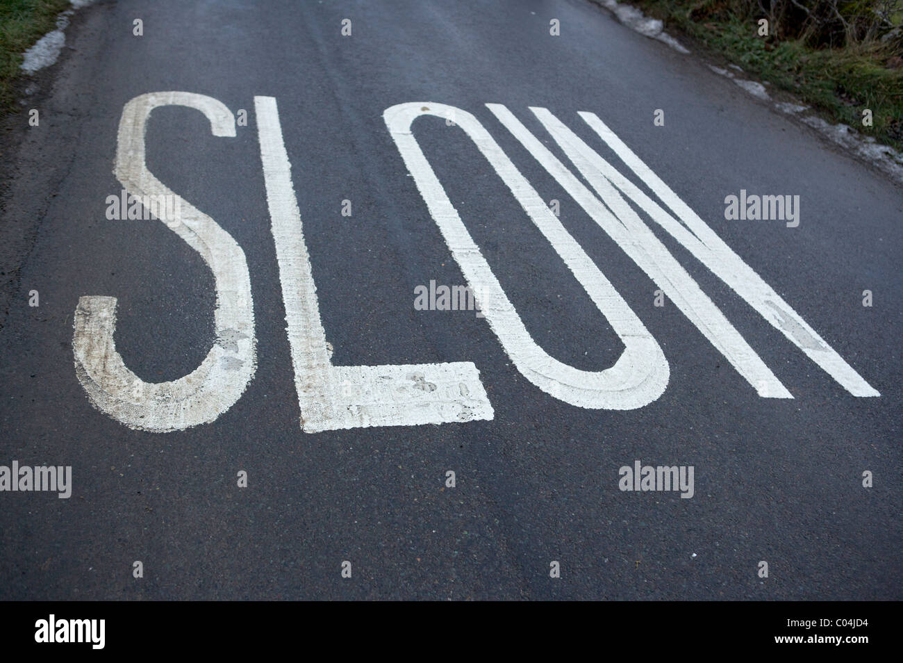 Slow sign painted on road Stock Photo - Alamy