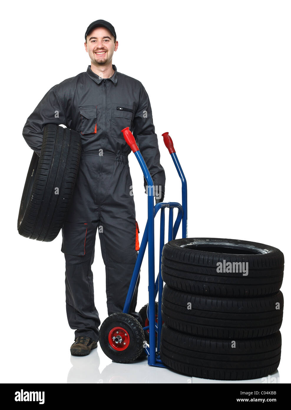 man with garage suit and tires on white background Stock Photo - Alamy