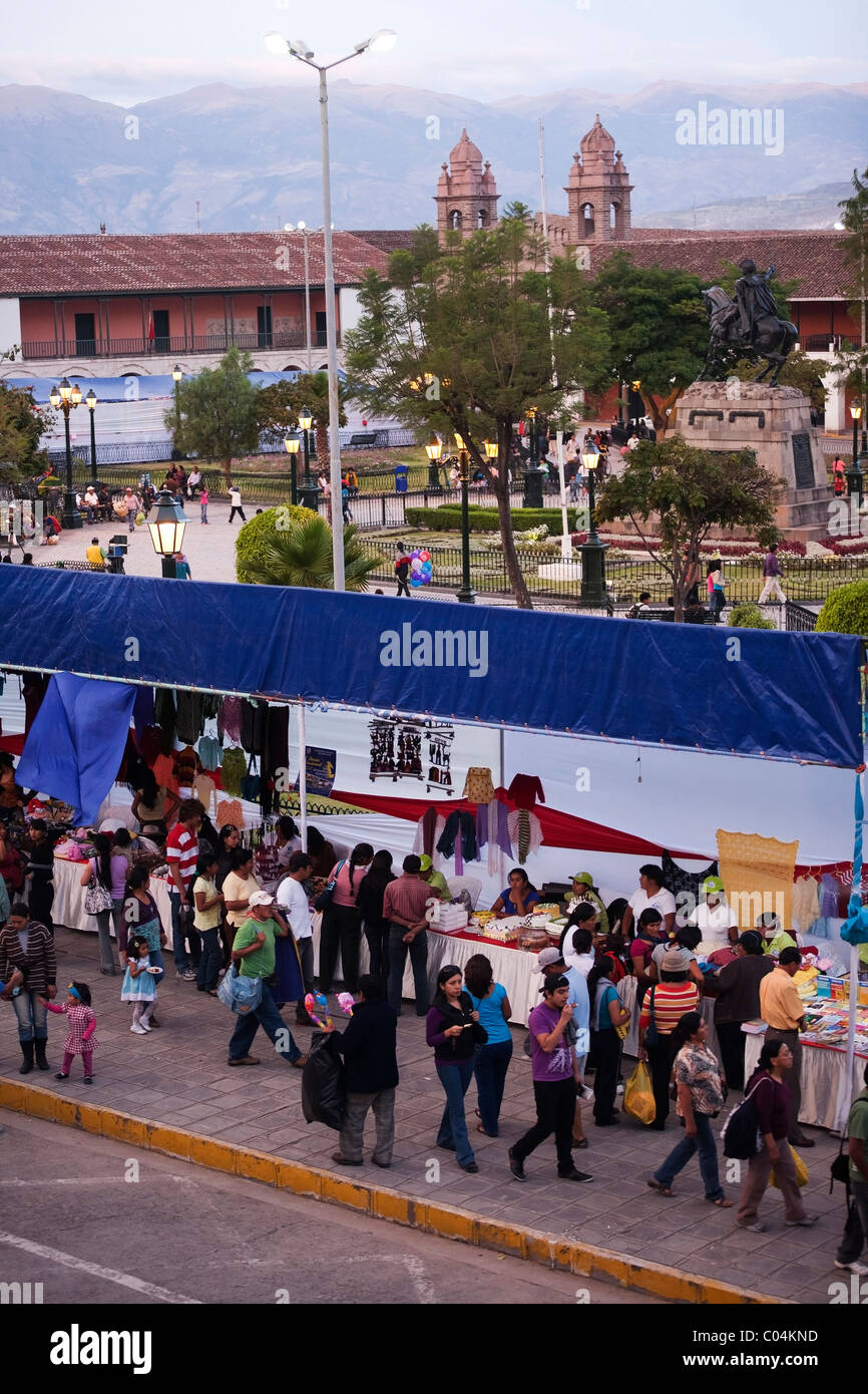 A weekend crowd pass stalls on the main sqaure of Ayacucho in Peru ...