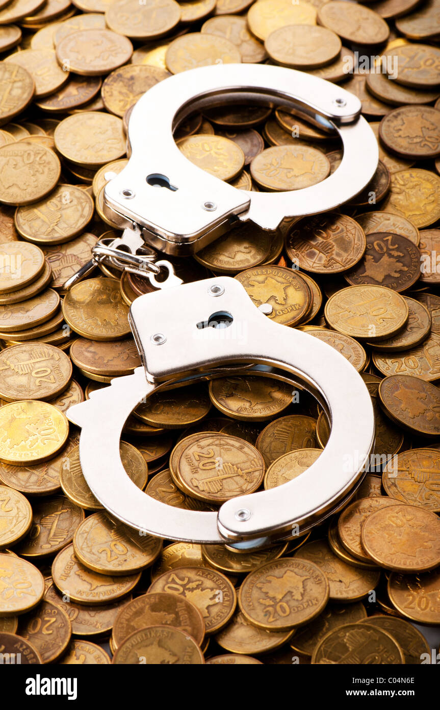 Hand cuffs and coins as security concept Stock Photo - Alamy