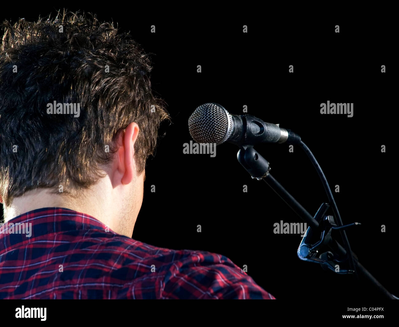 Young musician with his microphone on a dark background Stock Photo - Alamy
