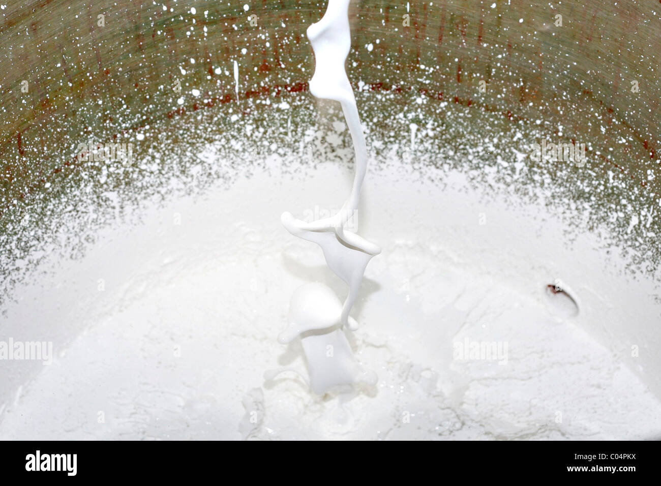 Flow of white paint falls into a bucket Stock Photo - Alamy