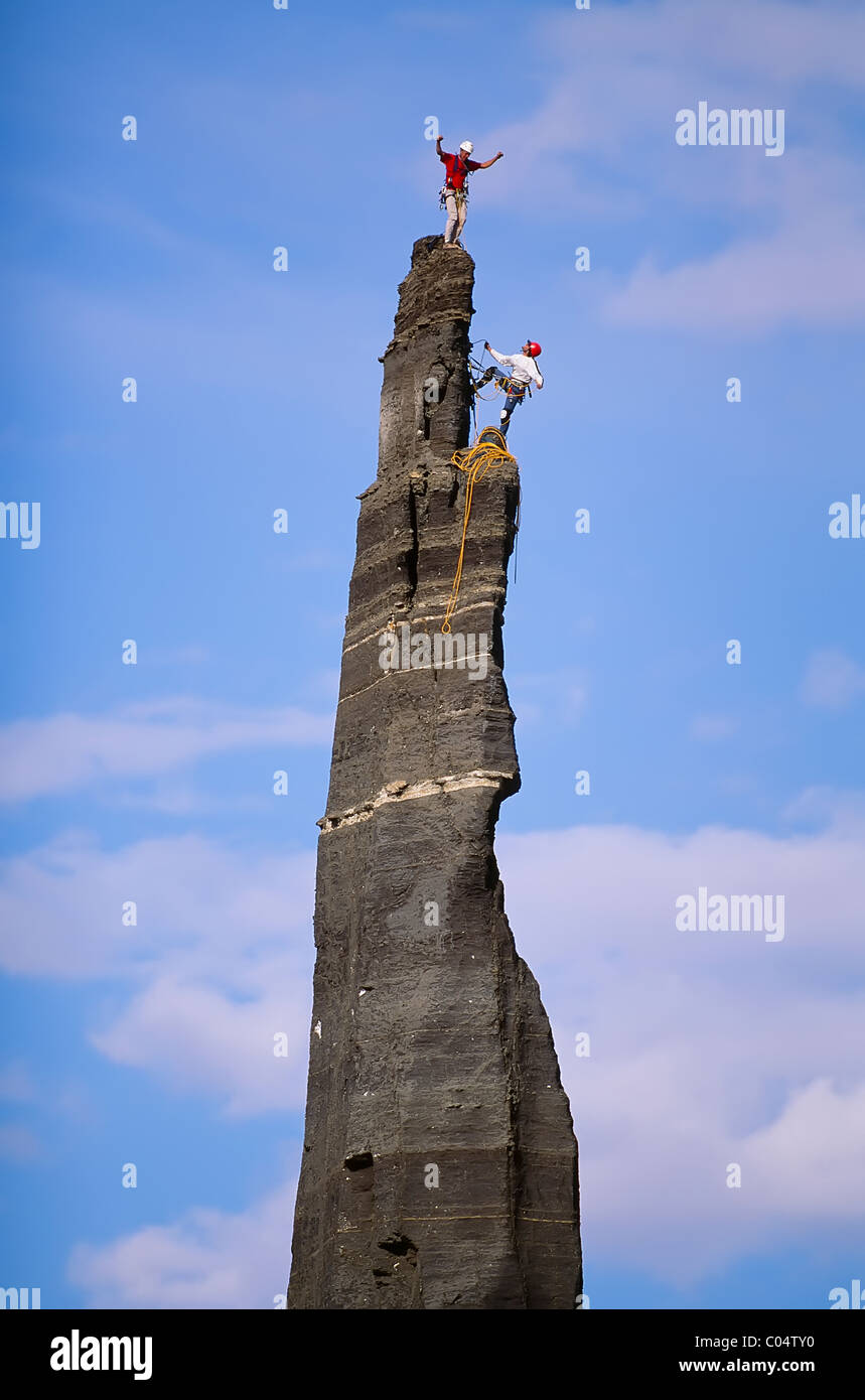 Team of climbers reaching the summit of a rock pinnacle Stock Photo - Alamy