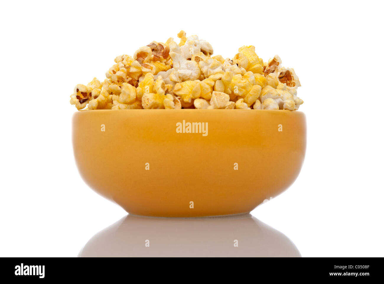 Delicious popcorn in yellow ceramic bowl over white background Stock ...