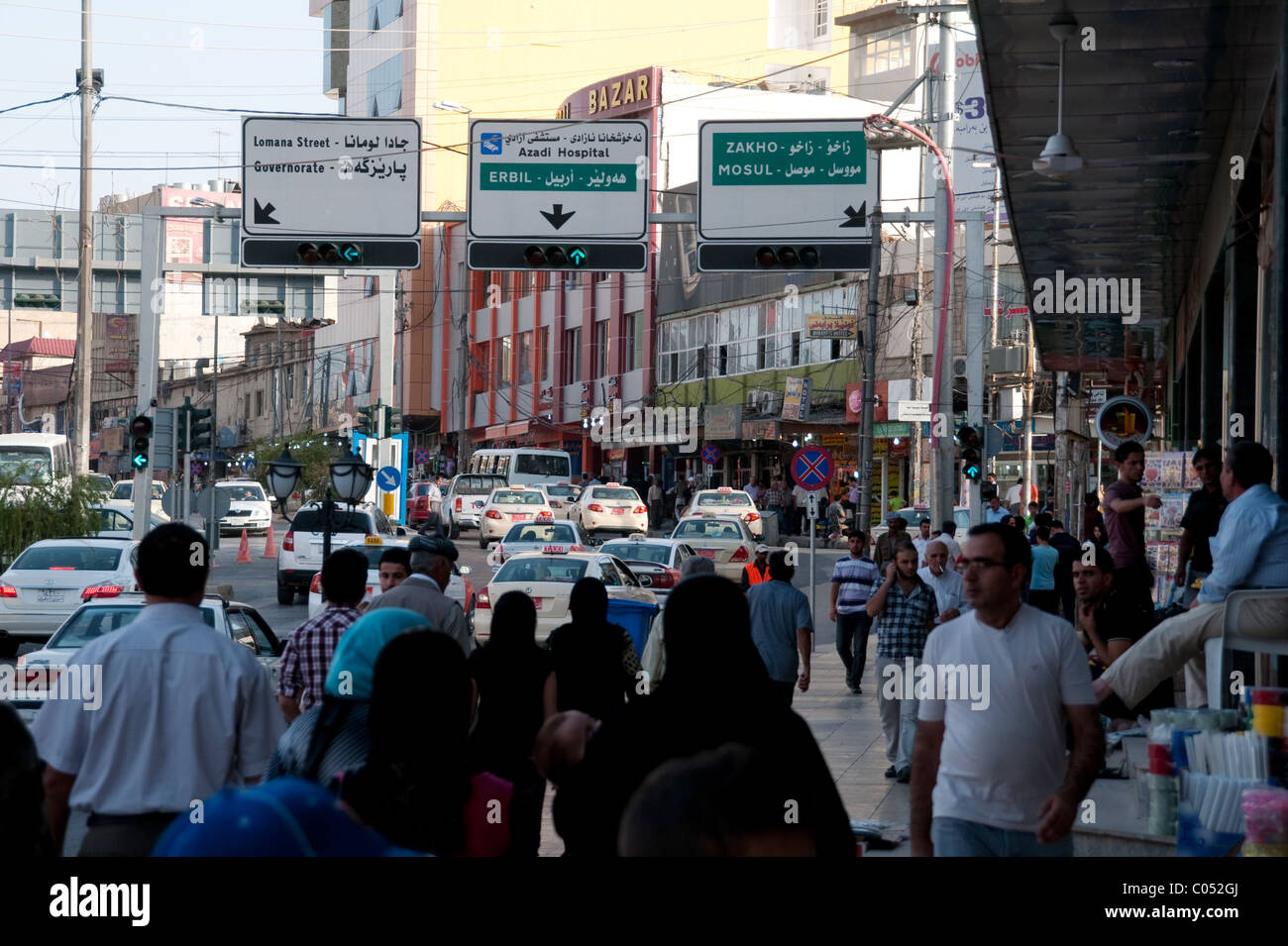 Car and pedestrian traffic along a busy main road in the Kurdish city ...