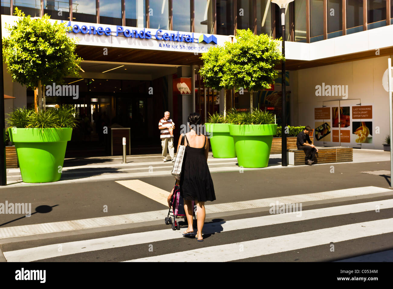 Mother pushing pram across street at pedestrian crossing Stock Photo ...