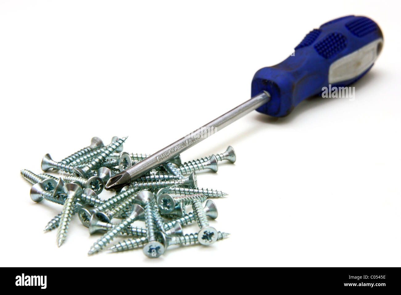 Screwdriver and small metal screws on a white background Stock Photo ...