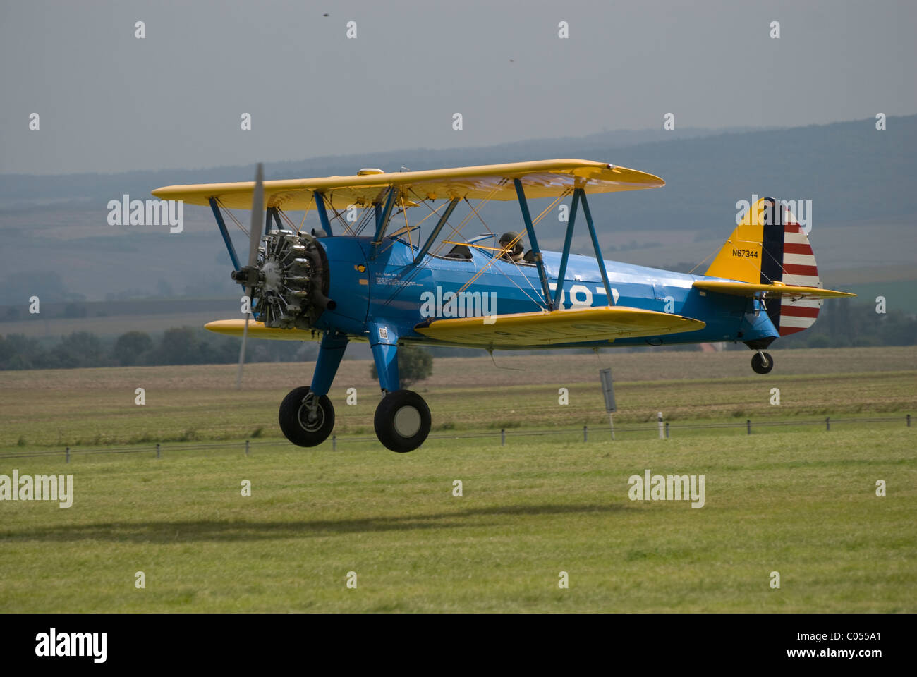 Biplane with star engine low pass - aircraft of type Boeing Stearman ...