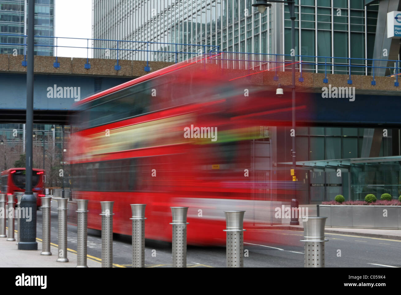 Two buses going under a bridge in Canary Wharf, London Stock Photo - Alamy