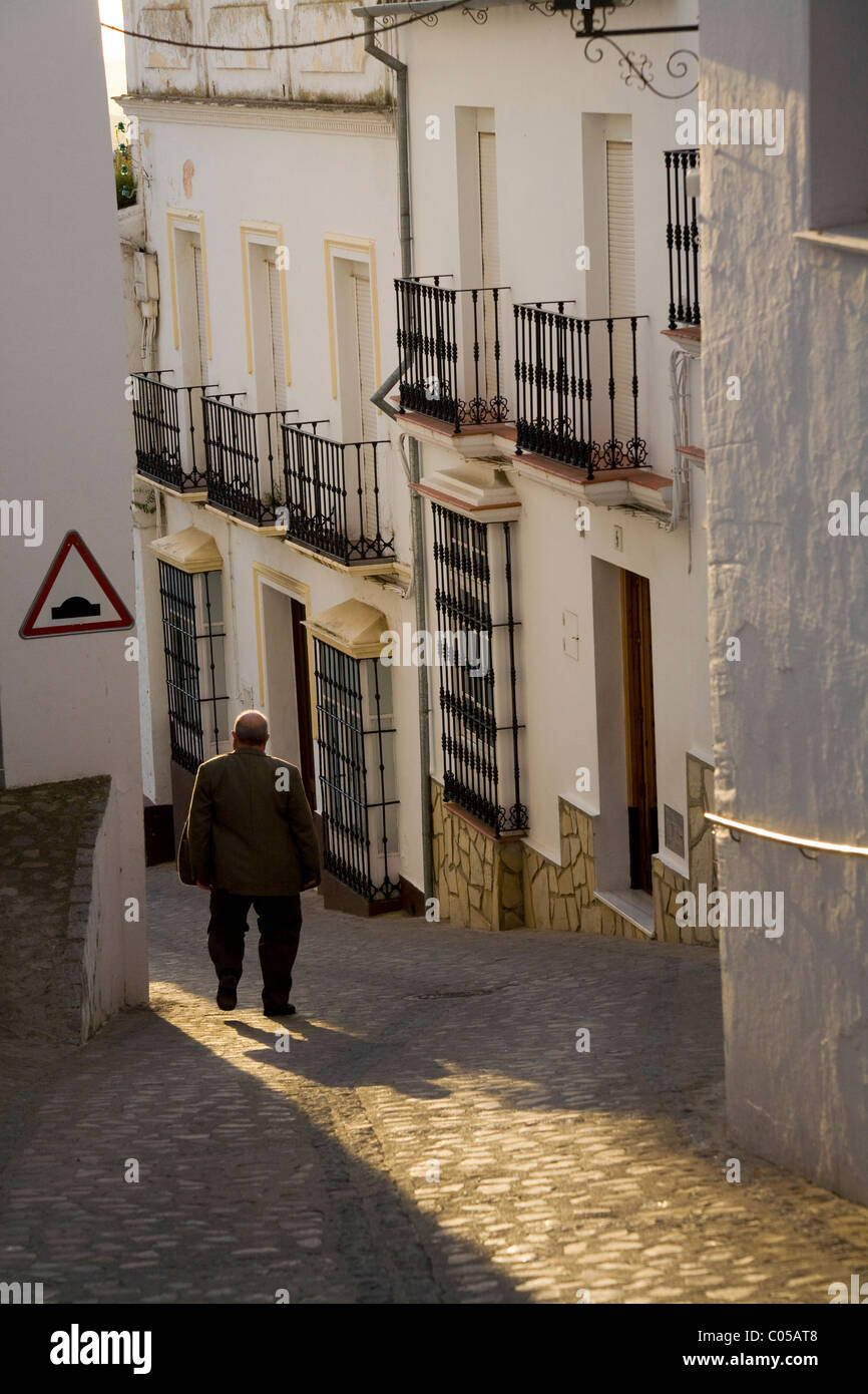 Man walks in traditional Spanish cobbled back street / streets / road ...
