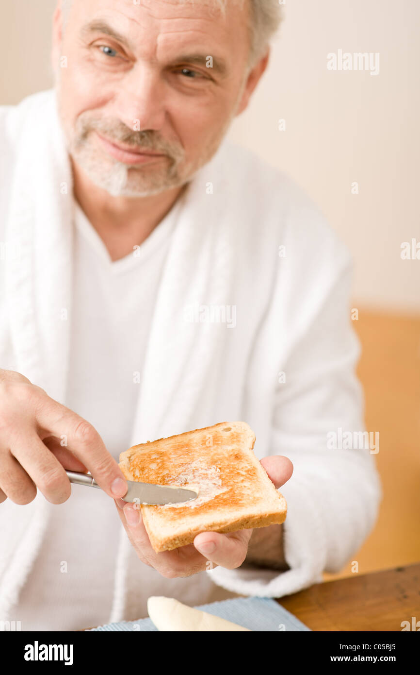 Senior mature man having breakfast butter toast wear bathrobe Stock ...